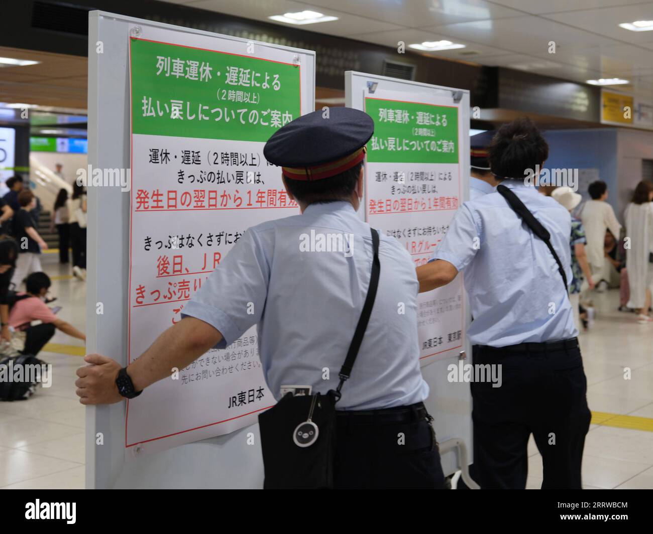 230816 -- TOKYO, Aug. 16, 2023 -- Staff members carry boards showing ...