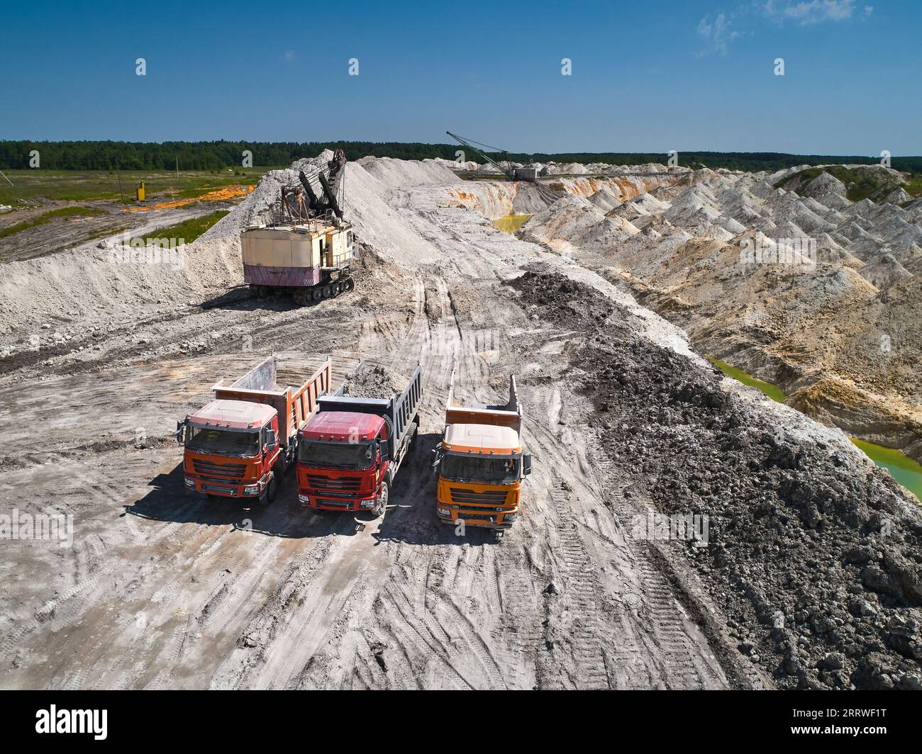 Red tipper trucks and shovel mining excavator in mining quarry Stock ...