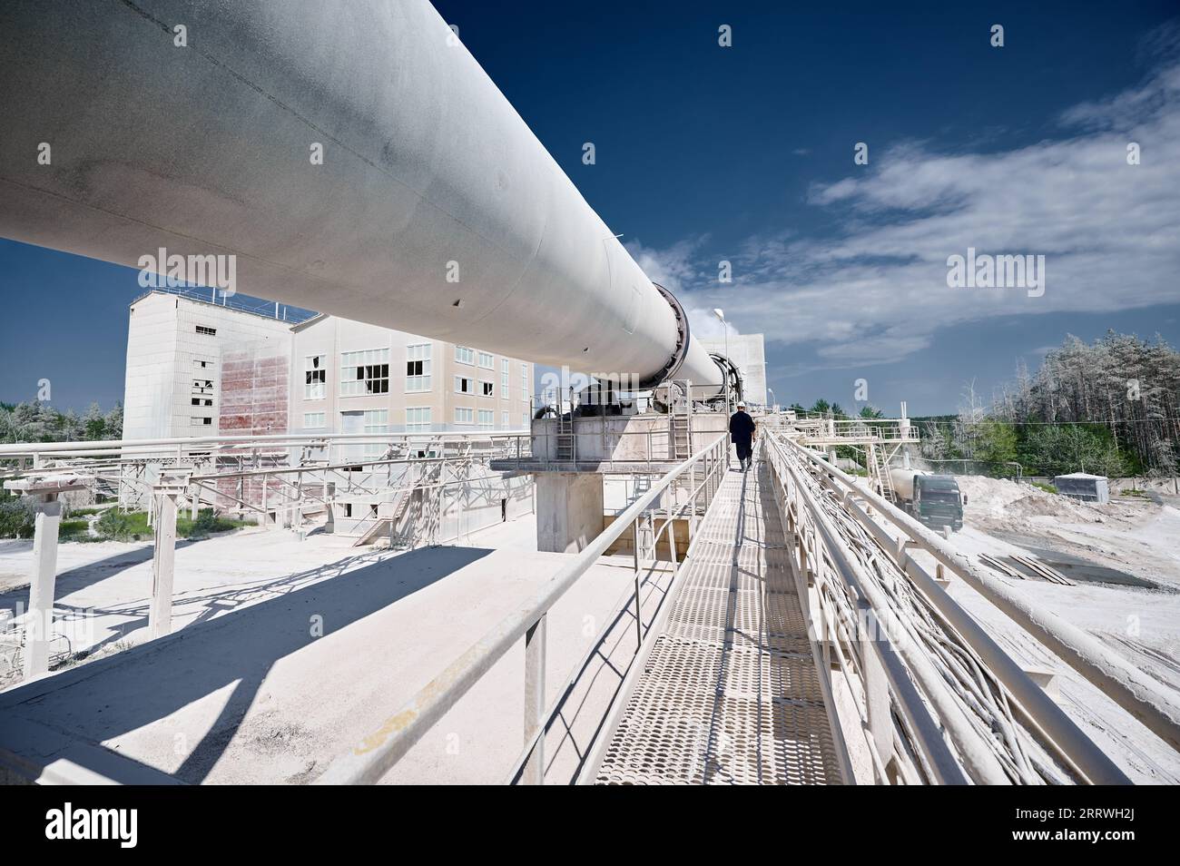 Worker walks along ladders for maintenance of rotary kiln Stock Photo ...