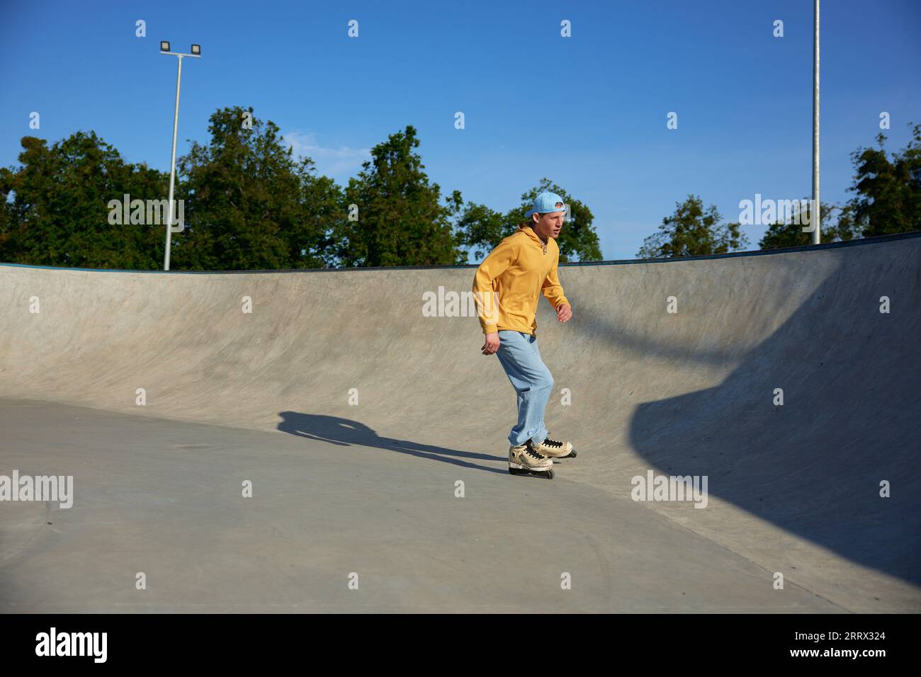 Skilled teenager boy wearing casual clothing and in roller blades ...