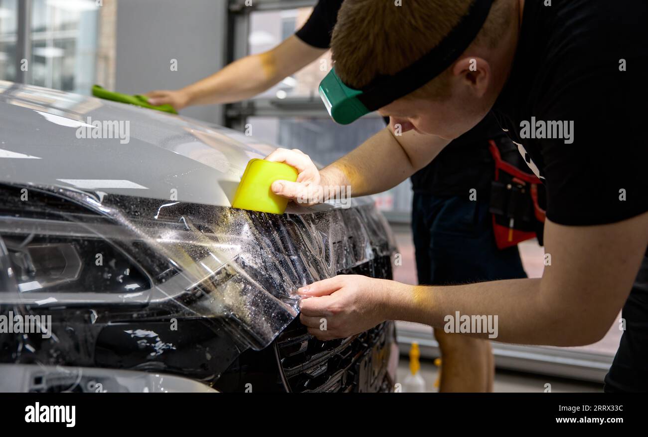 Polyurethane vinyl film pasting on car hood procedure closeup Stock ...