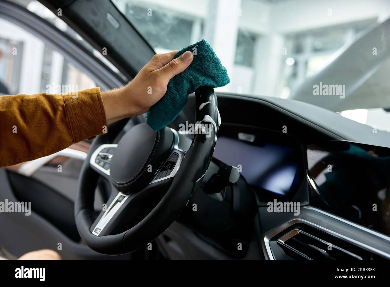 Male hands washing steering wheel with rag, car interior dry cleansing ...