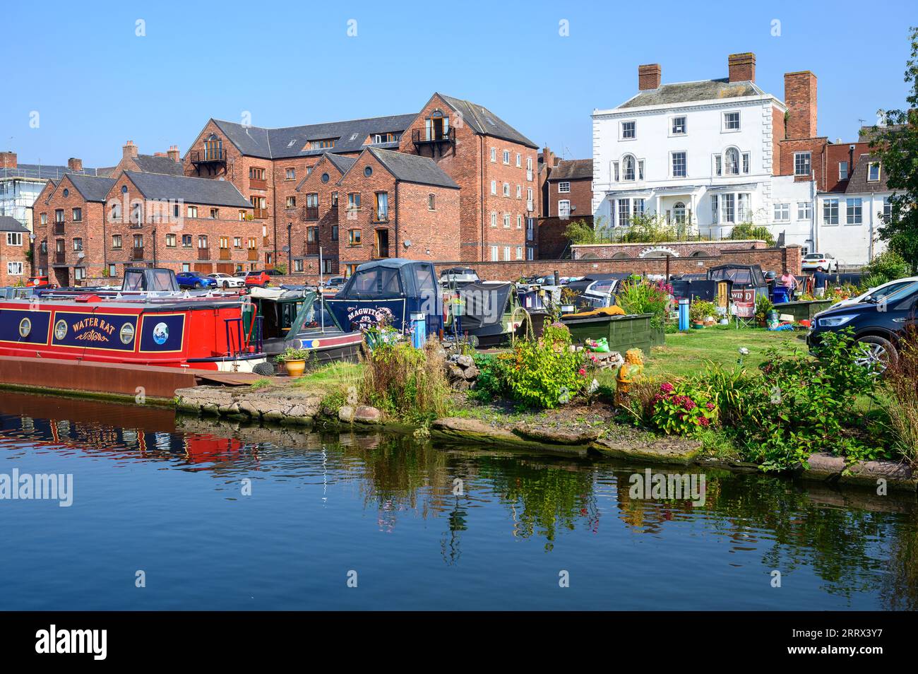 Narrowboats moored in front of the old and new houses that surround the ...