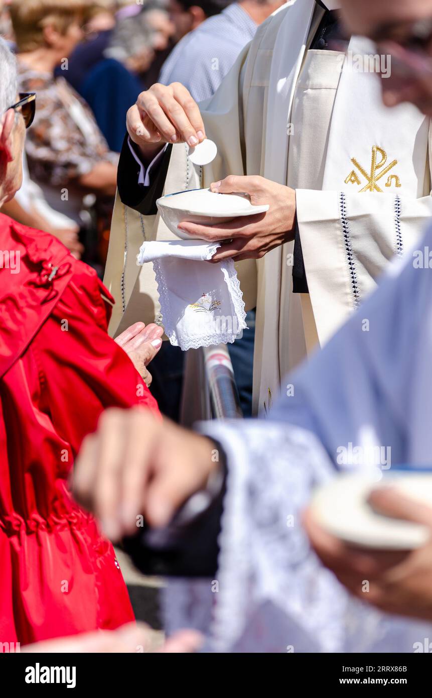 Selective focus, catholic priests distributing the communion wafer ...