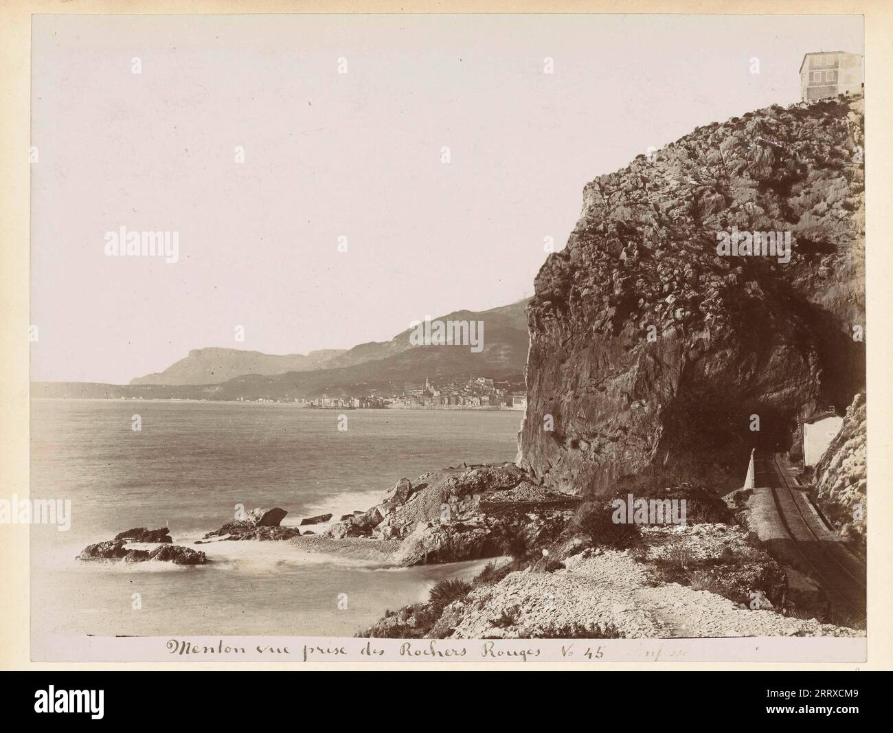 The rocky coast of Menton with a railway line in the front right that ...