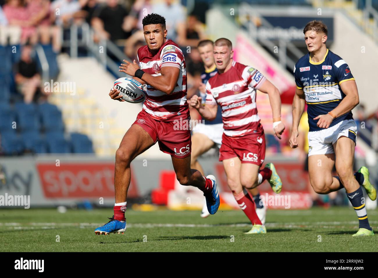 Wigan Warriors' Kai Pearce-Paul (left) breaks away to score a try ...