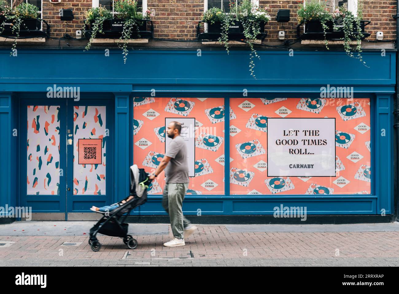 LONDON, UK - AUGUST 27, 2023: Blurred man with baby stroller walks in ...