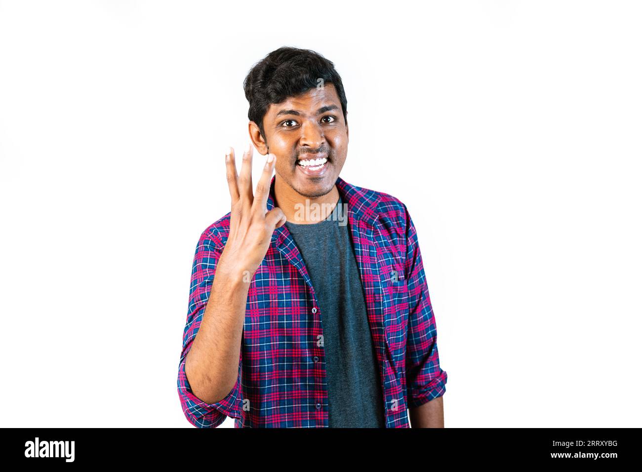 A man is raising his hand with three fingers extended. The background ...