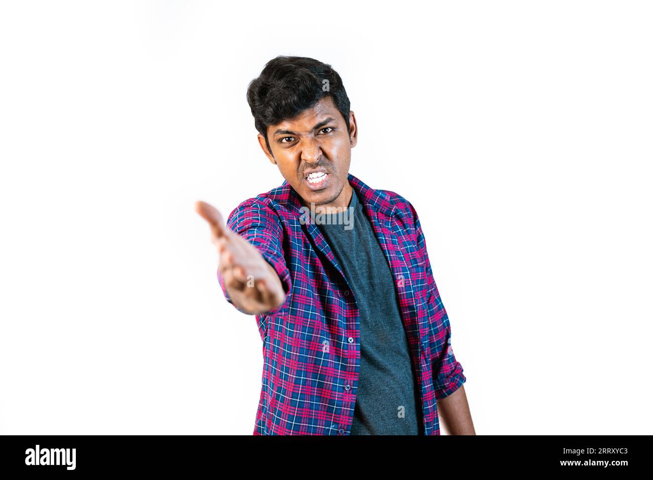 A young man with short dark hair and stubble is making an angry gesture ...