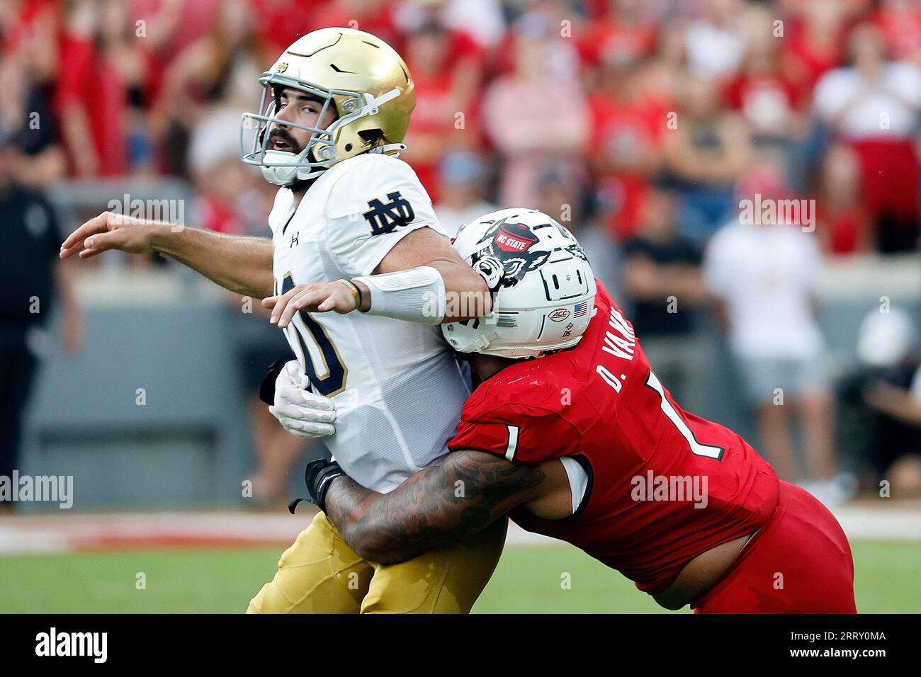 Notre Dame's Sam Hartman (10) is hit by North Carolina State's Davin ...