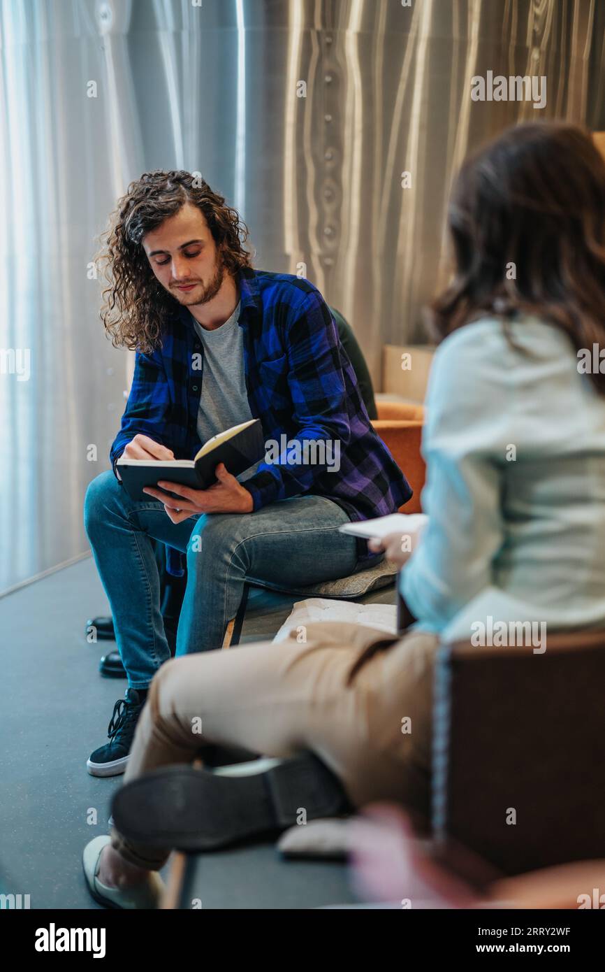 Focused teammates working on a mutual tasks at work while sitting at ...