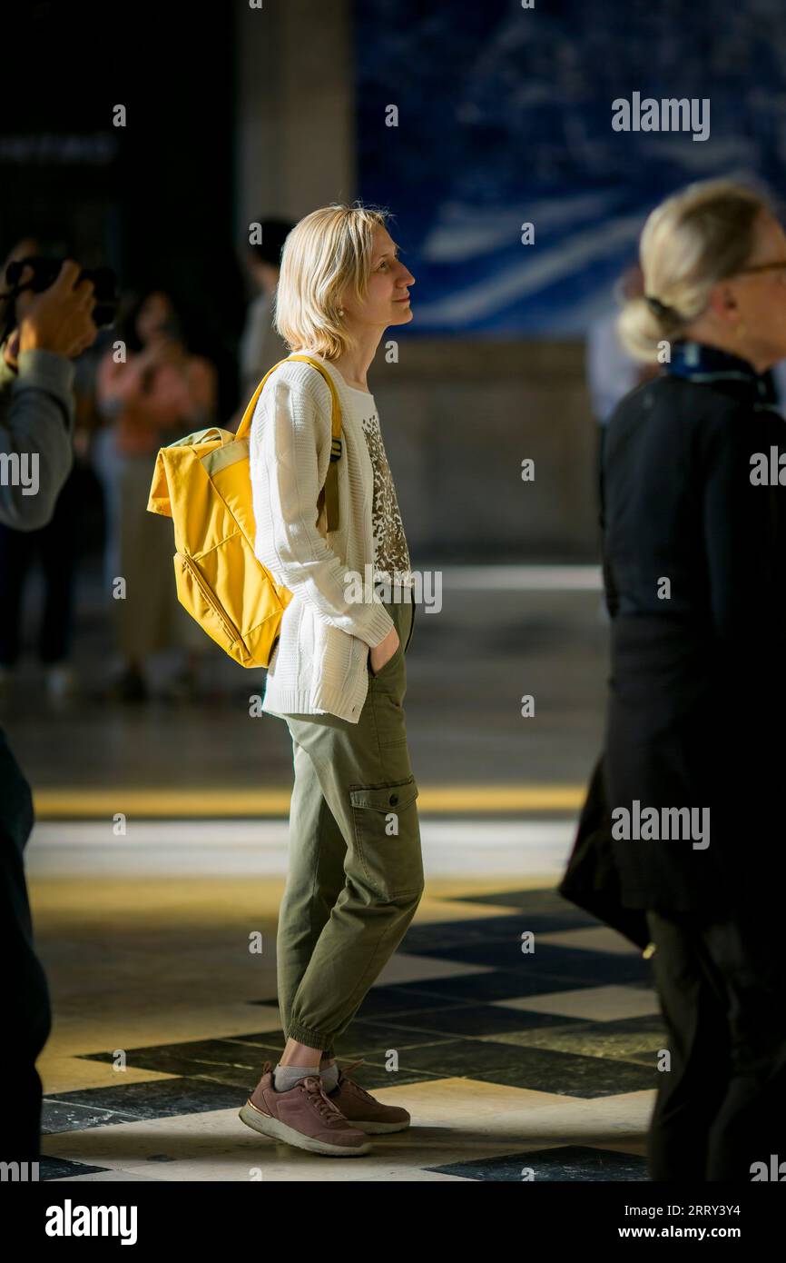 A woman stands in the Sao Bento station building against a background ...