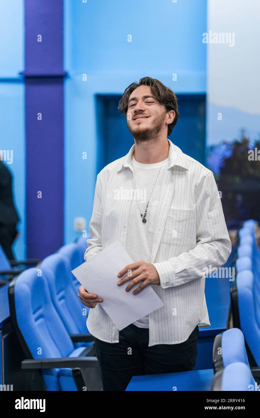 Student holding paperwork posing and smiling at the classroom Stock ...