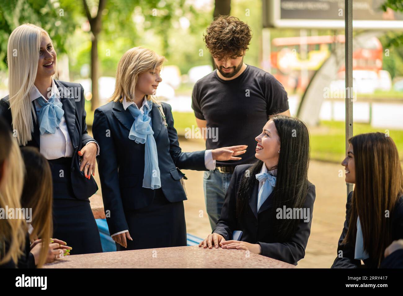 Group of students having meeting at table after classes, outdoors Stock ...
