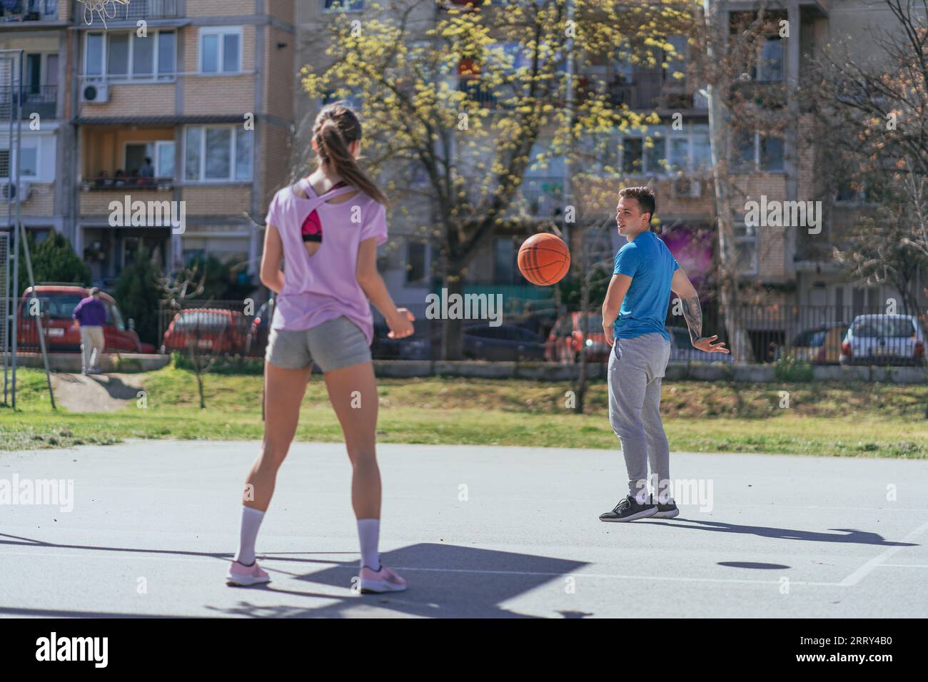 Passing basketball from the back. Male sports person having fun with ...