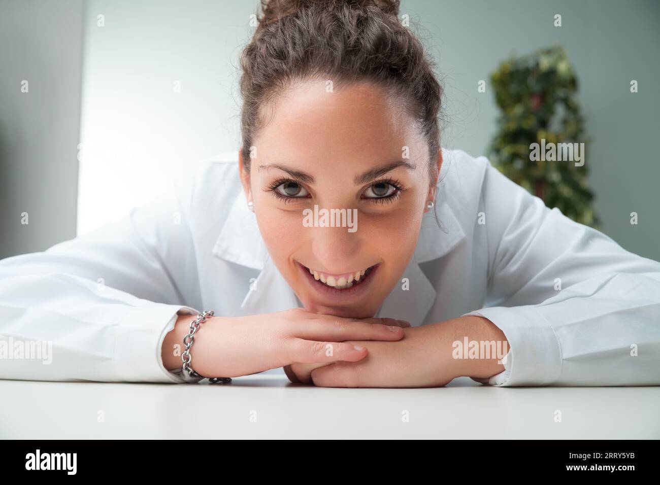 Resting her chin on her hands in an office, a technical expert or ...