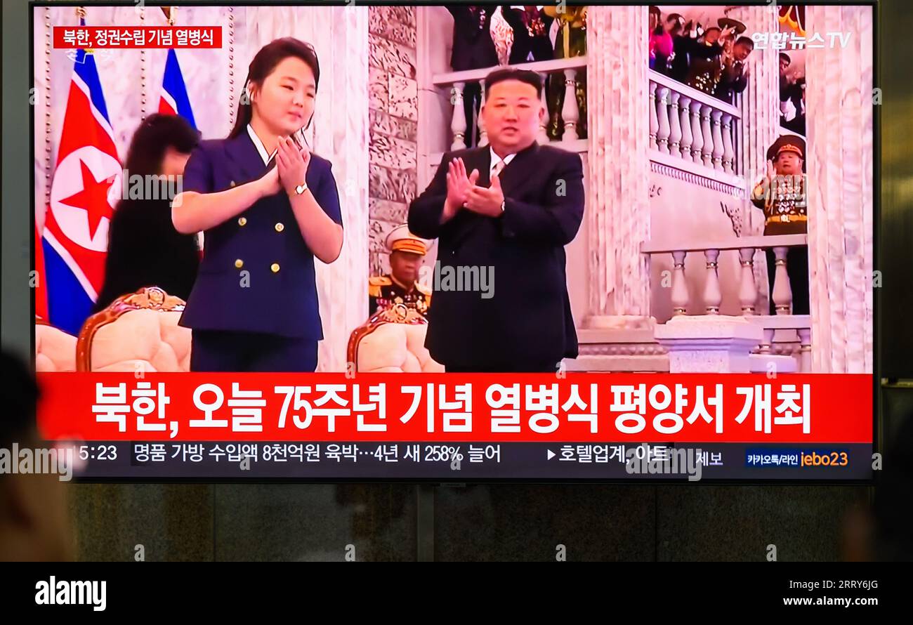 A TV screen shows the North Korean leader Kim Jong Un (R) and his ...