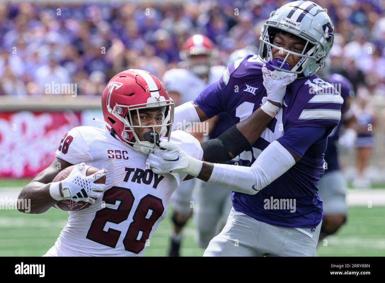 Troy running back Kimani Vidal (28) fights off a tackle by Kansas State ...
