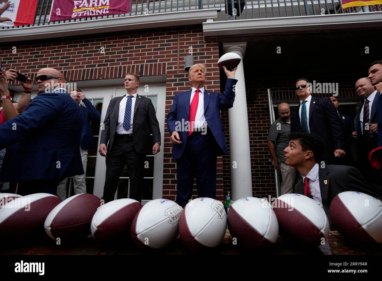 Former President Donald Trump holds a football before throwing it to ...