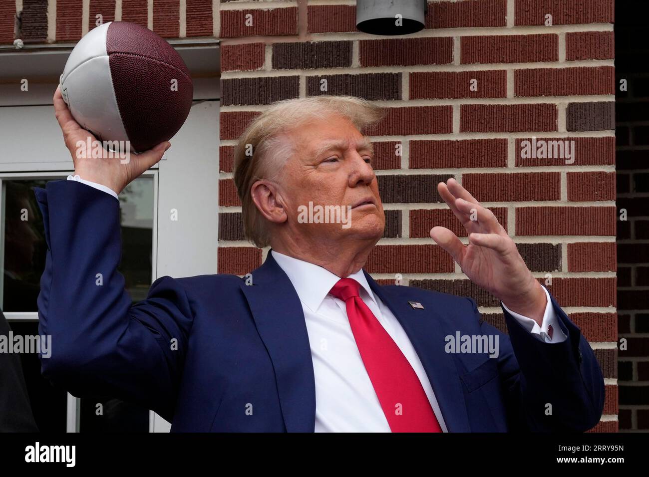Former President Donald Trump prepares to throw a football to the crowd ...