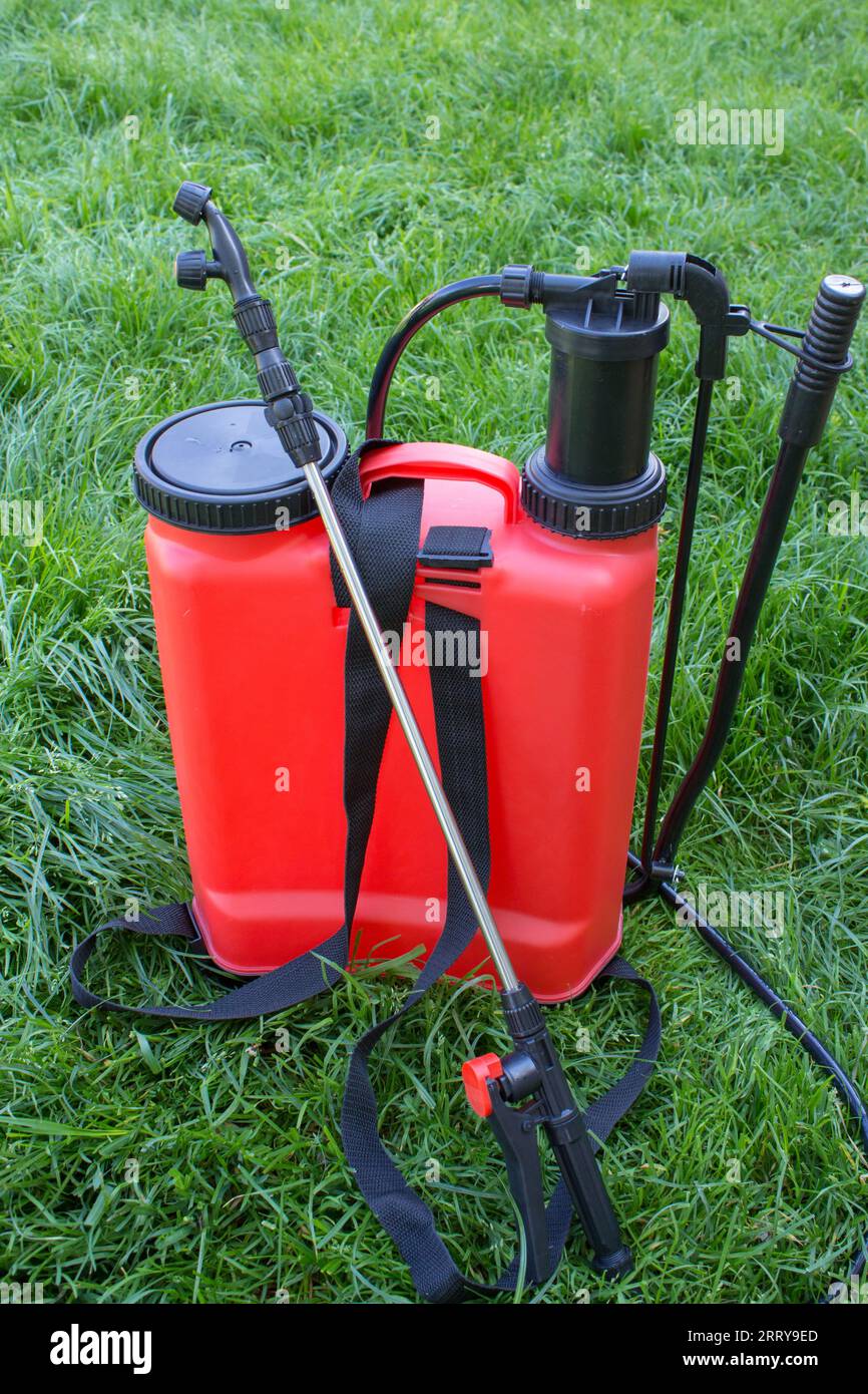 On the grass there is a red garden sprayer for the farm Stock Photo - Alamy