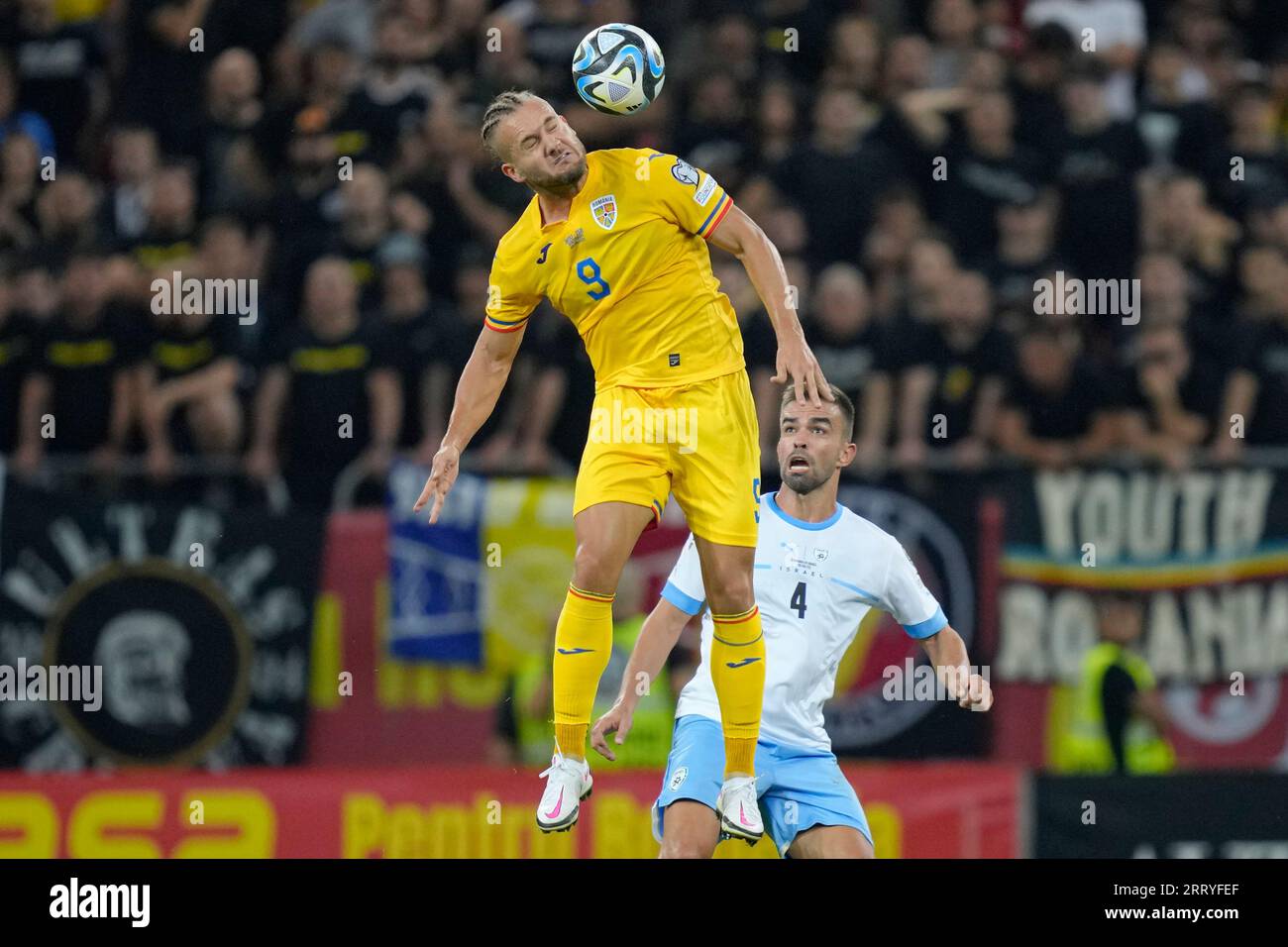 Romania's George Puscas jumps for a header during the Euro 2024 ...