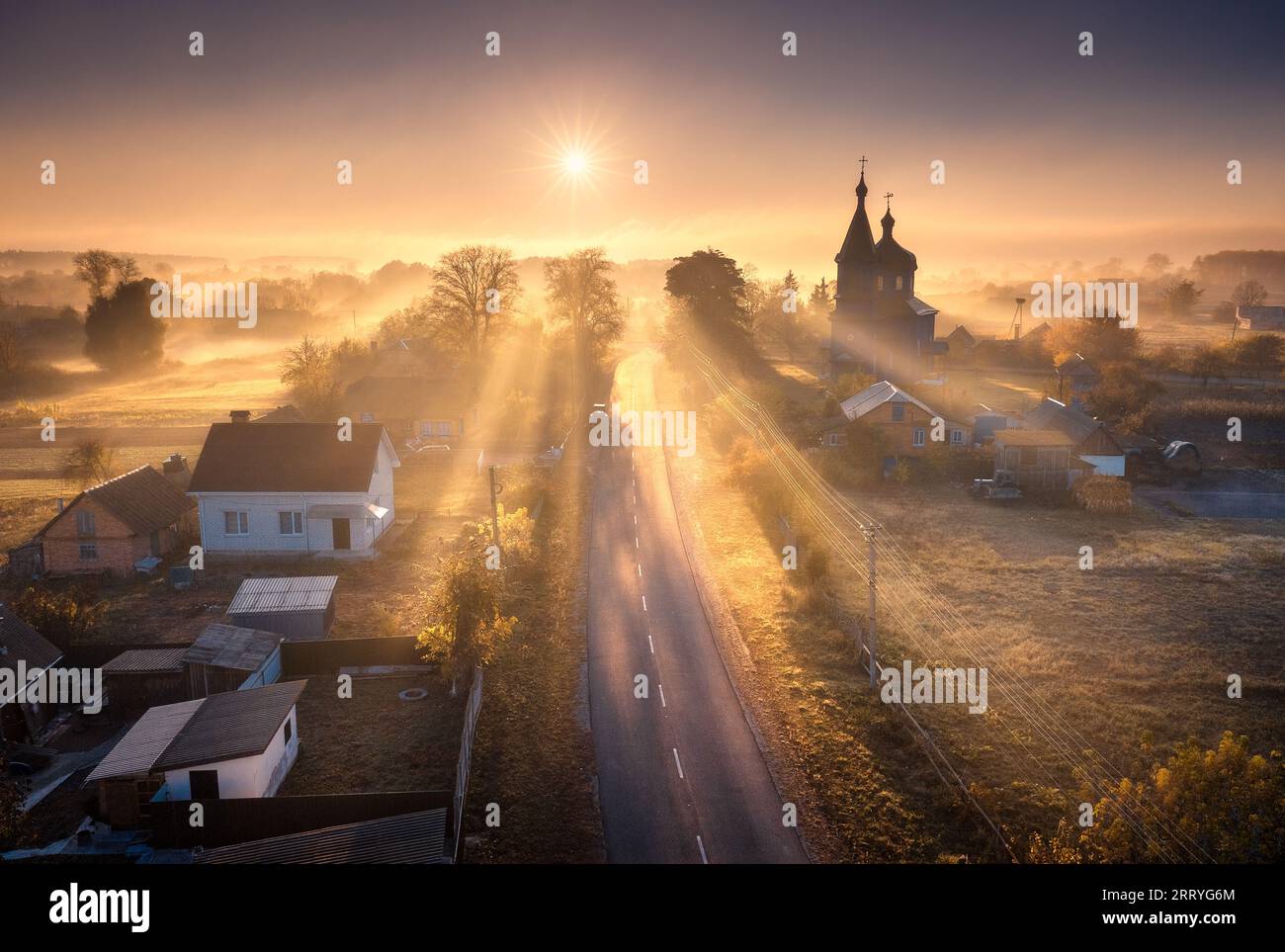 Aerial view of village in fog with golden sunbeams at sunrise Stock ...
