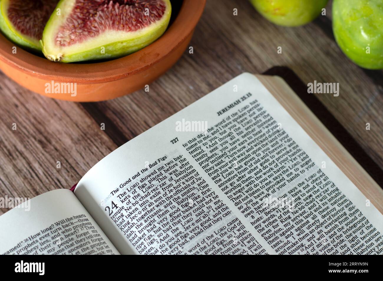 Fresh figs and open holy bible book on wooden table. Jeremiah 24 ...