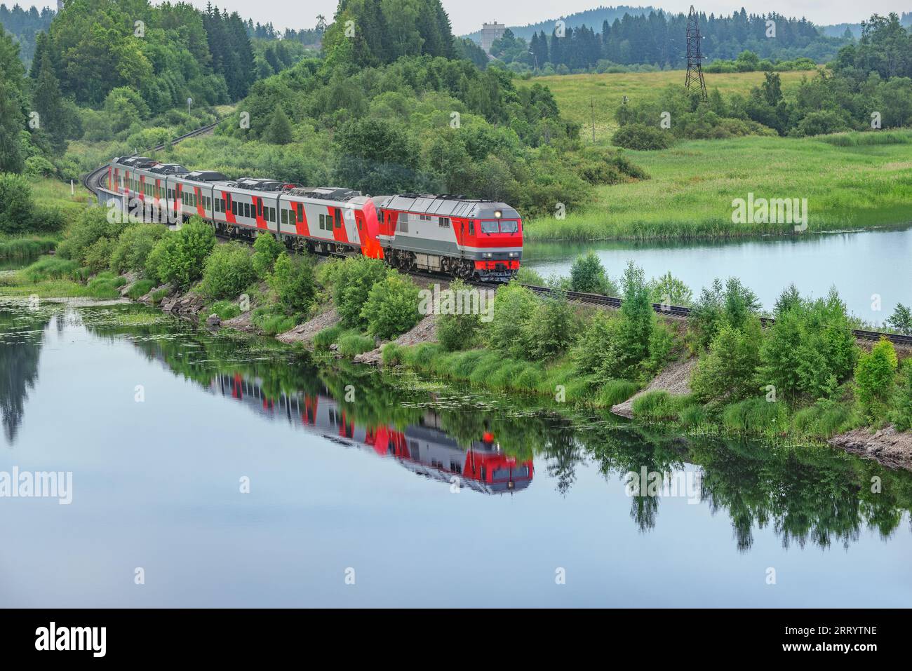 Passenger train moves along the lake Stock Photo - Alamy