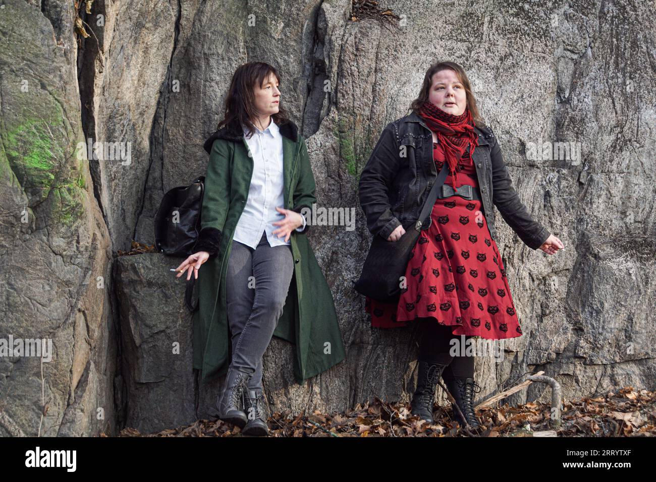 Two woman smoking in front of a rock Stock Photo - Alamy