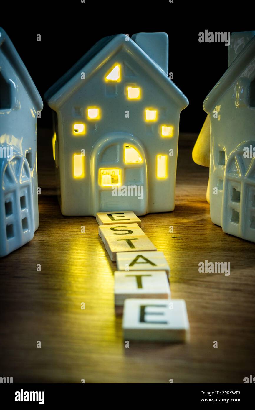 estate sign in wooden letters leading to ceramic house with light on ...