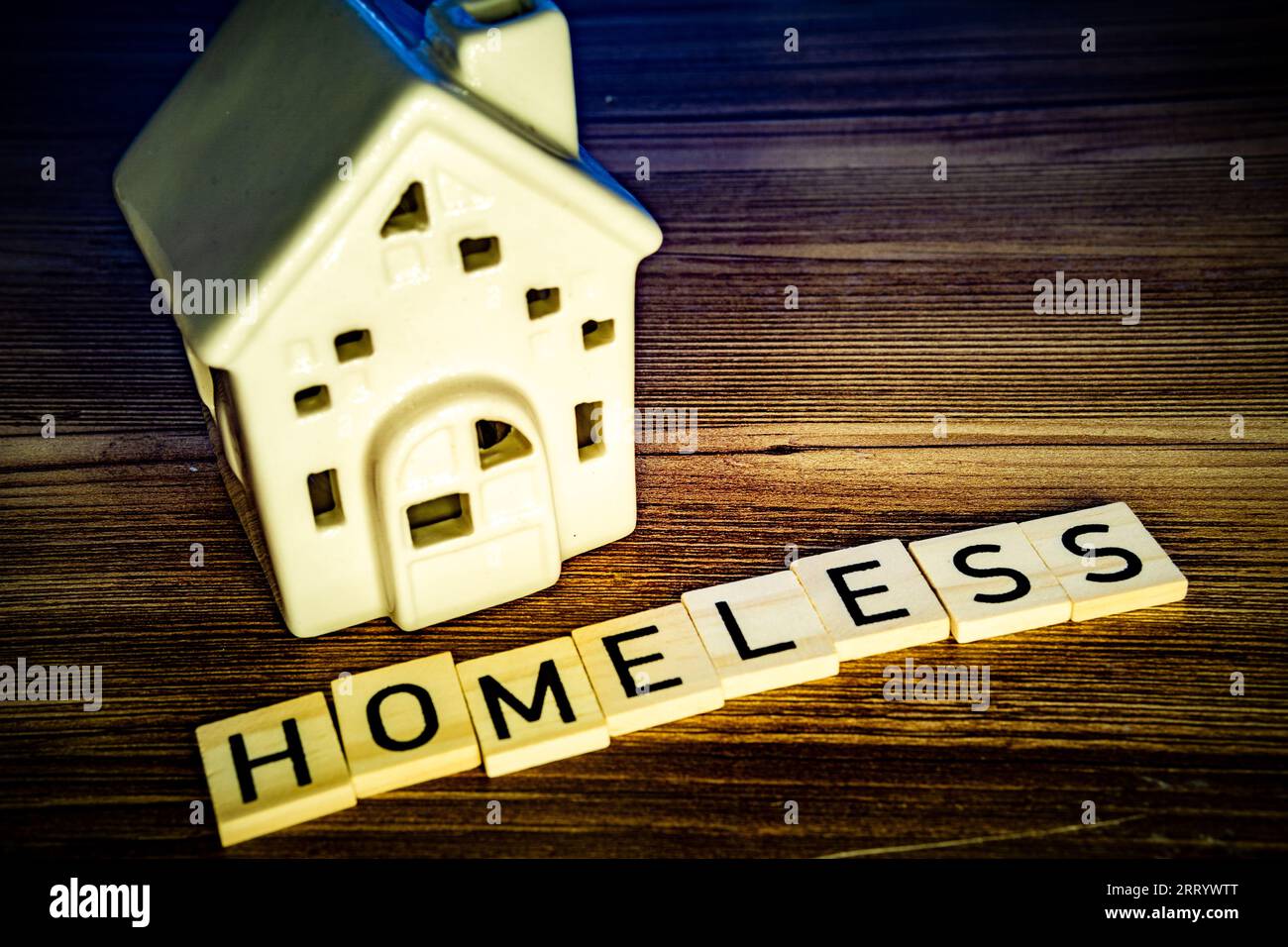 Word homeless in wooden letters on a wood background, with a ceramic ...