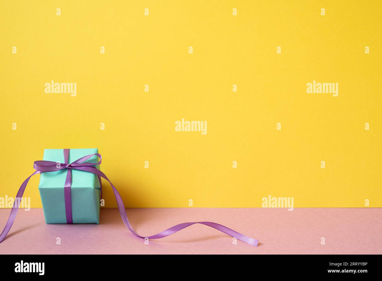 Mint green gift box on pink table. yellow background. copy space Stock ...