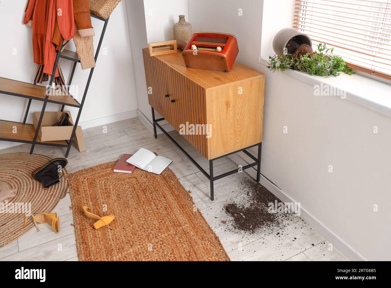 Chest of drawers and rack with clothes in messy room Stock Photo - Alamy