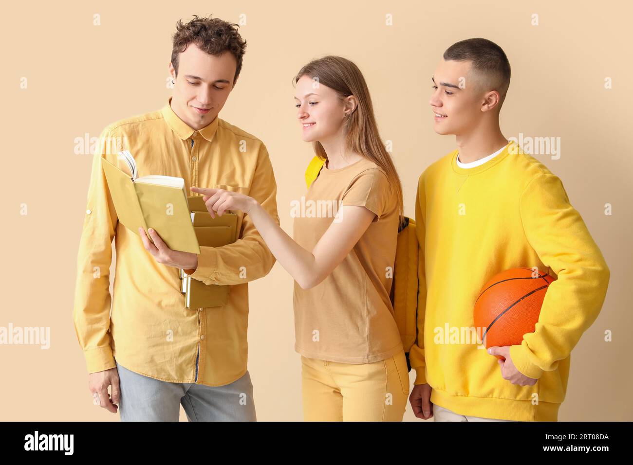 Group of students with books and ball on pale yellow background Stock ...