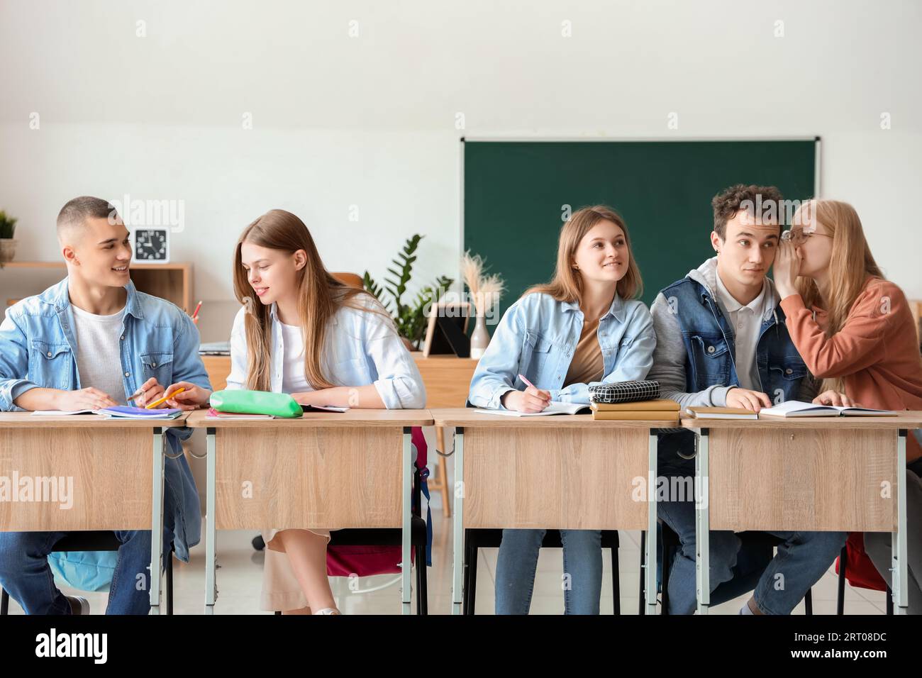 Students sitting and gossiping with his classmates in classroom Stock ...