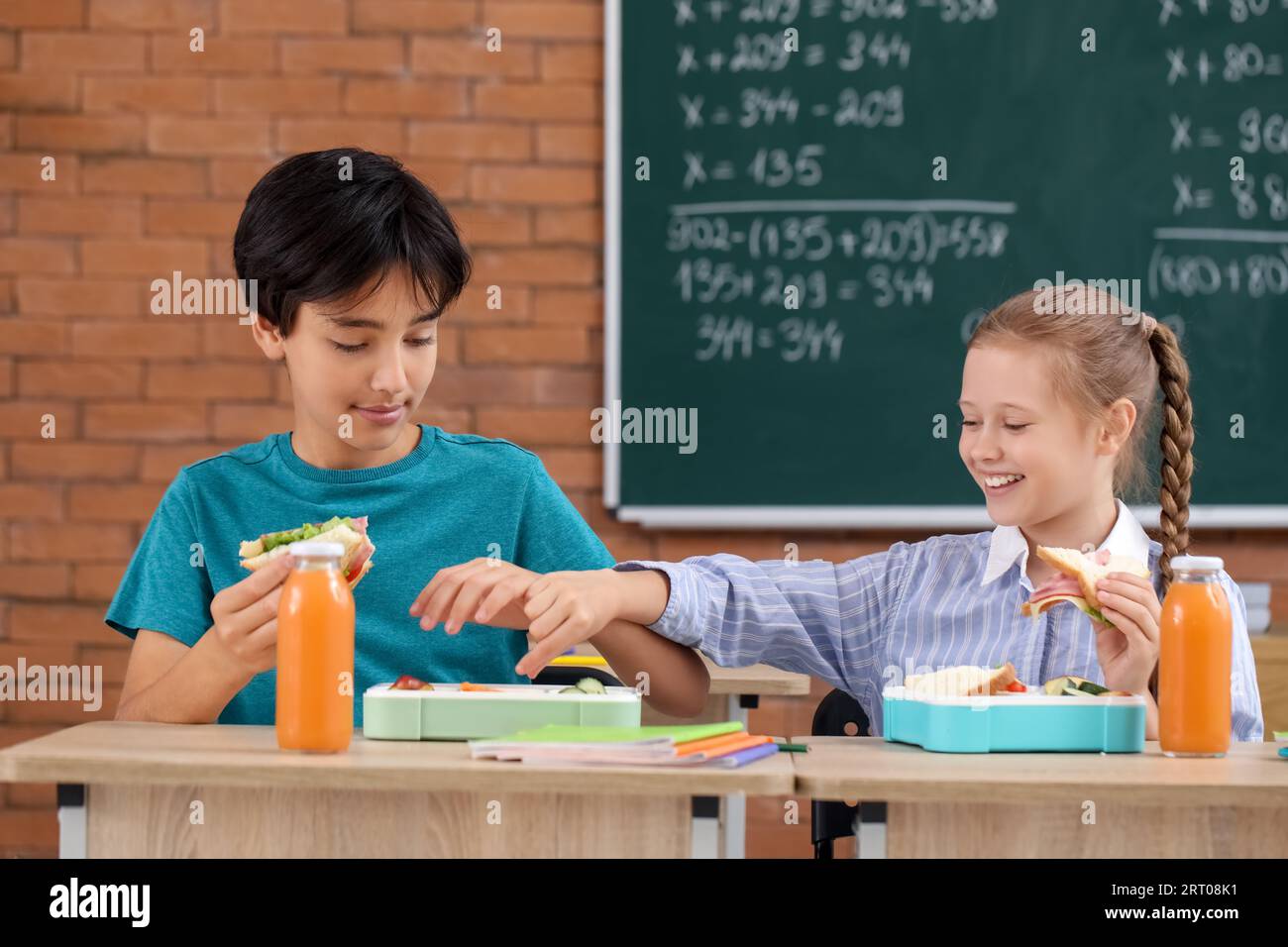 Little pupils having lunch in classroom Stock Photo - Alamy