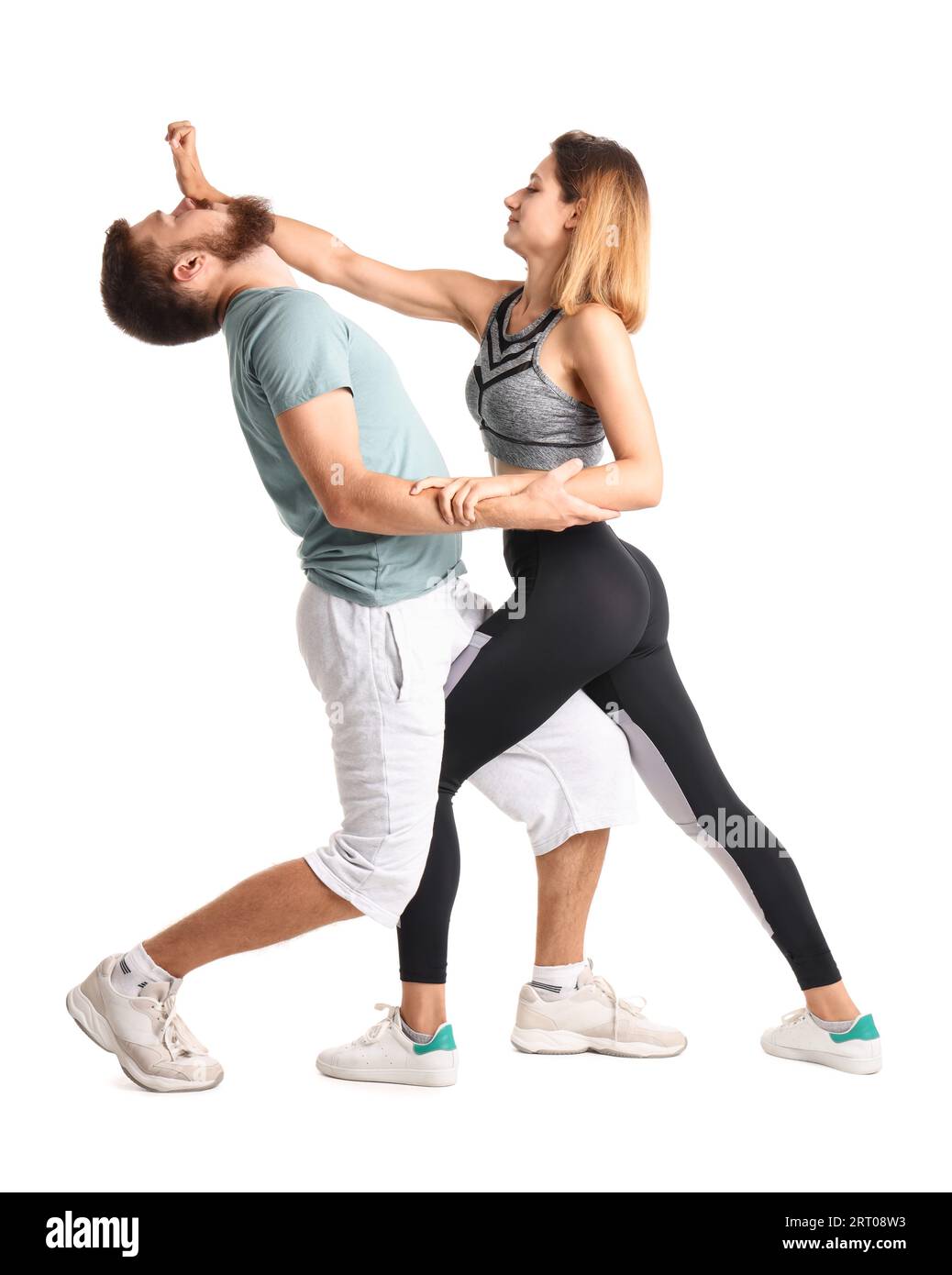 Young woman fighting with instructor of self-defence course on white ...