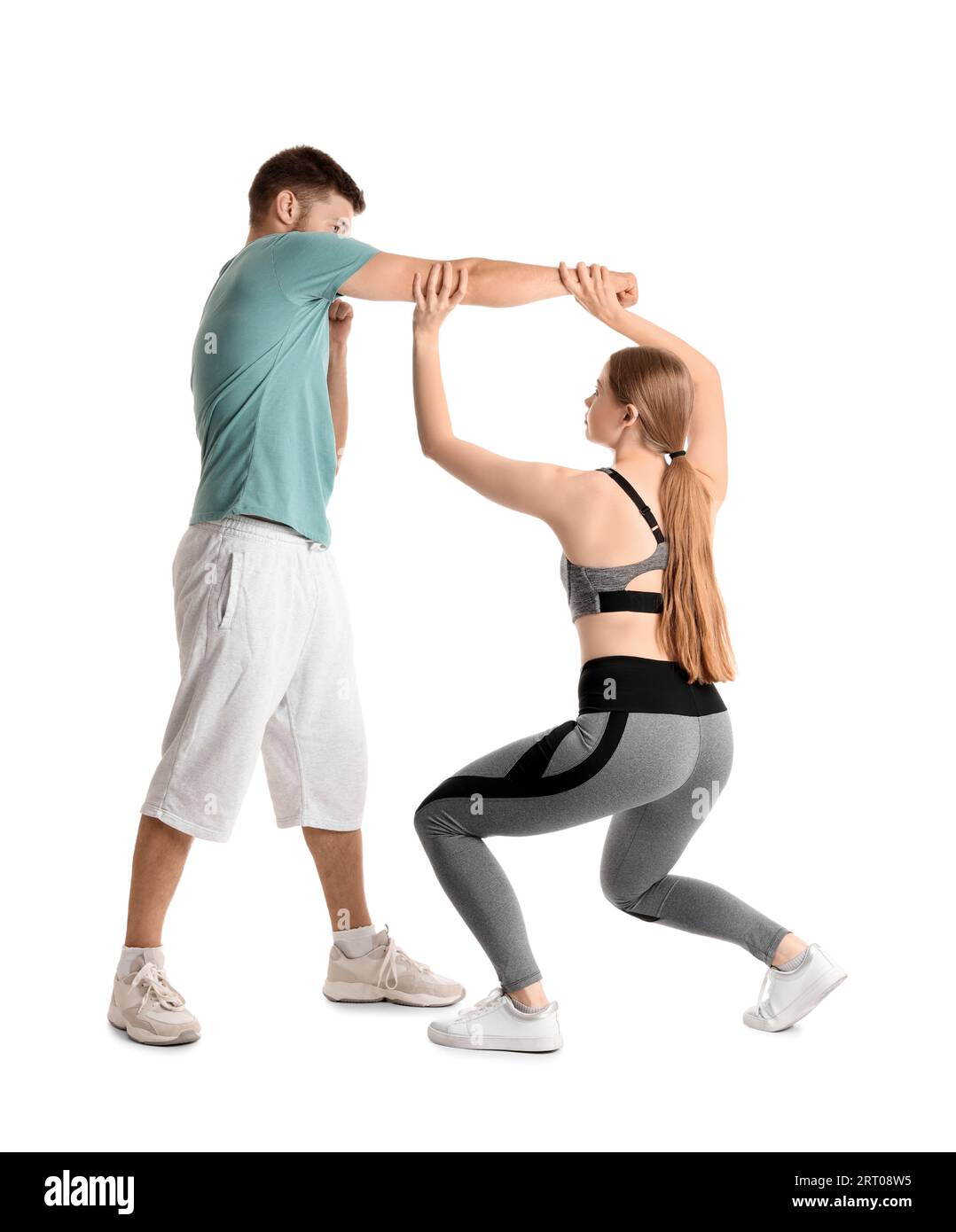 Young woman fighting with instructor of self-defence course on white ...