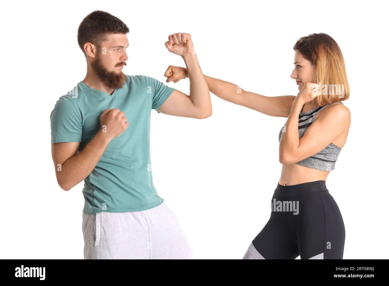 Young woman fighting with instructor of self-defence course on white ...