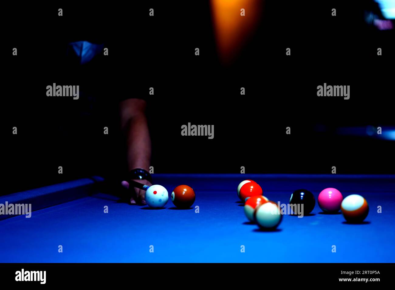 The hand holding the billiard cue, ready to make a precise strike on ...