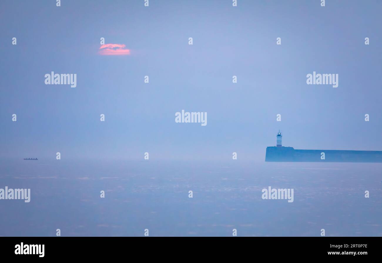 Sun setting behind Newhaven lighthouse haze and low cloud from Seaford ...