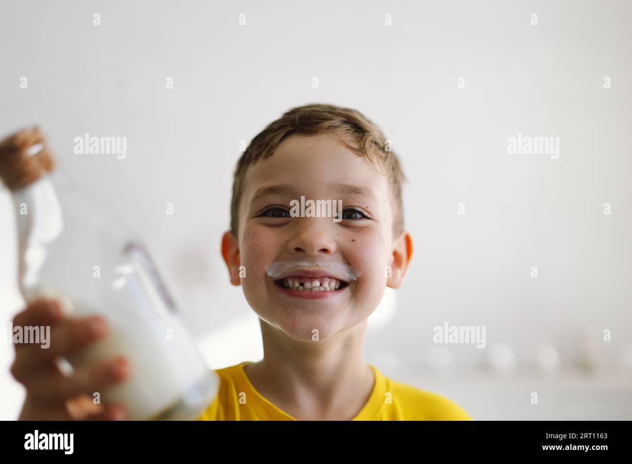 Cute boy drinks kefir or milk. Funny portrait of a boy with a milk ...