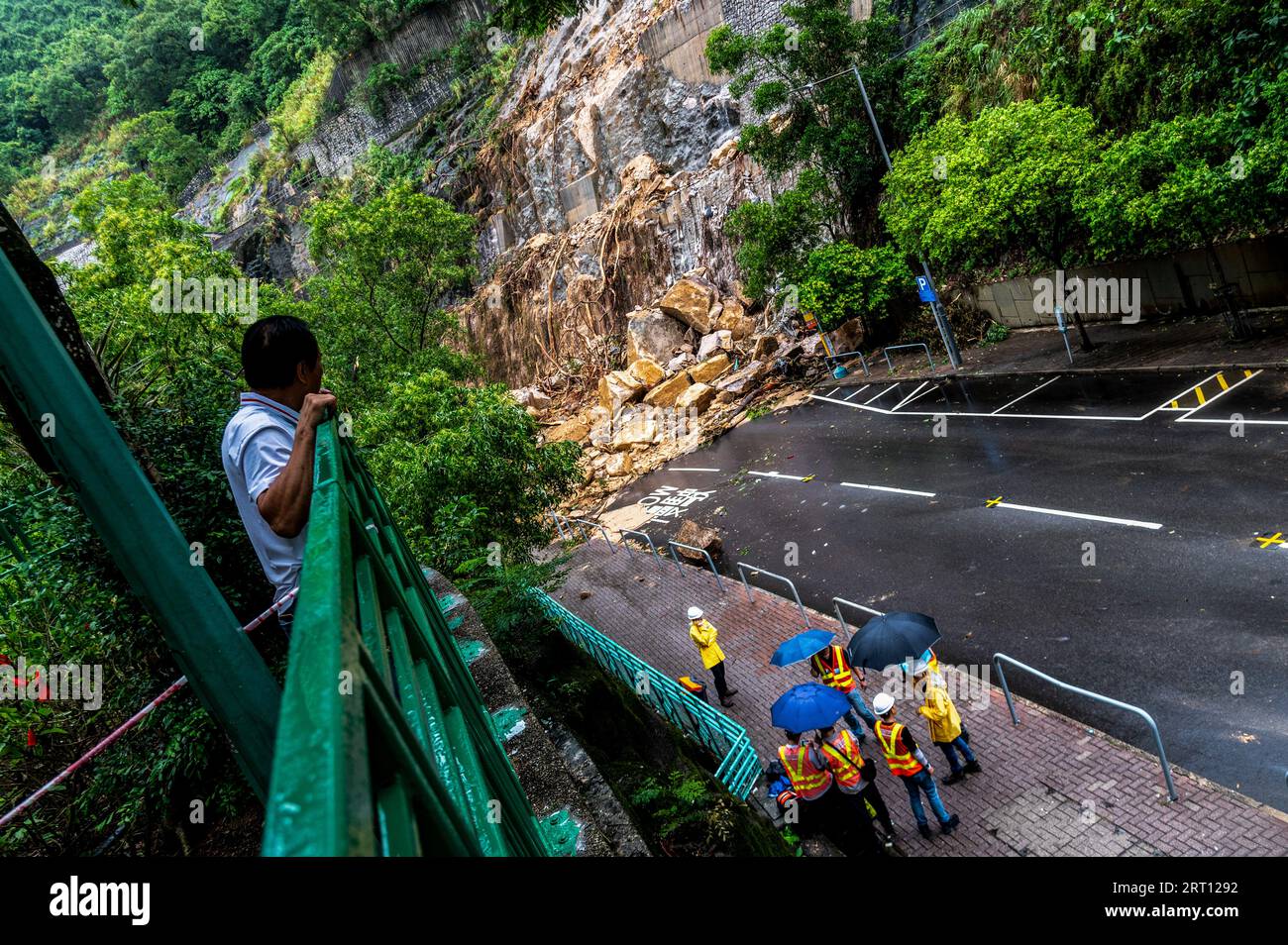 A man takes in the view while workers strategize their clean up efforts ...