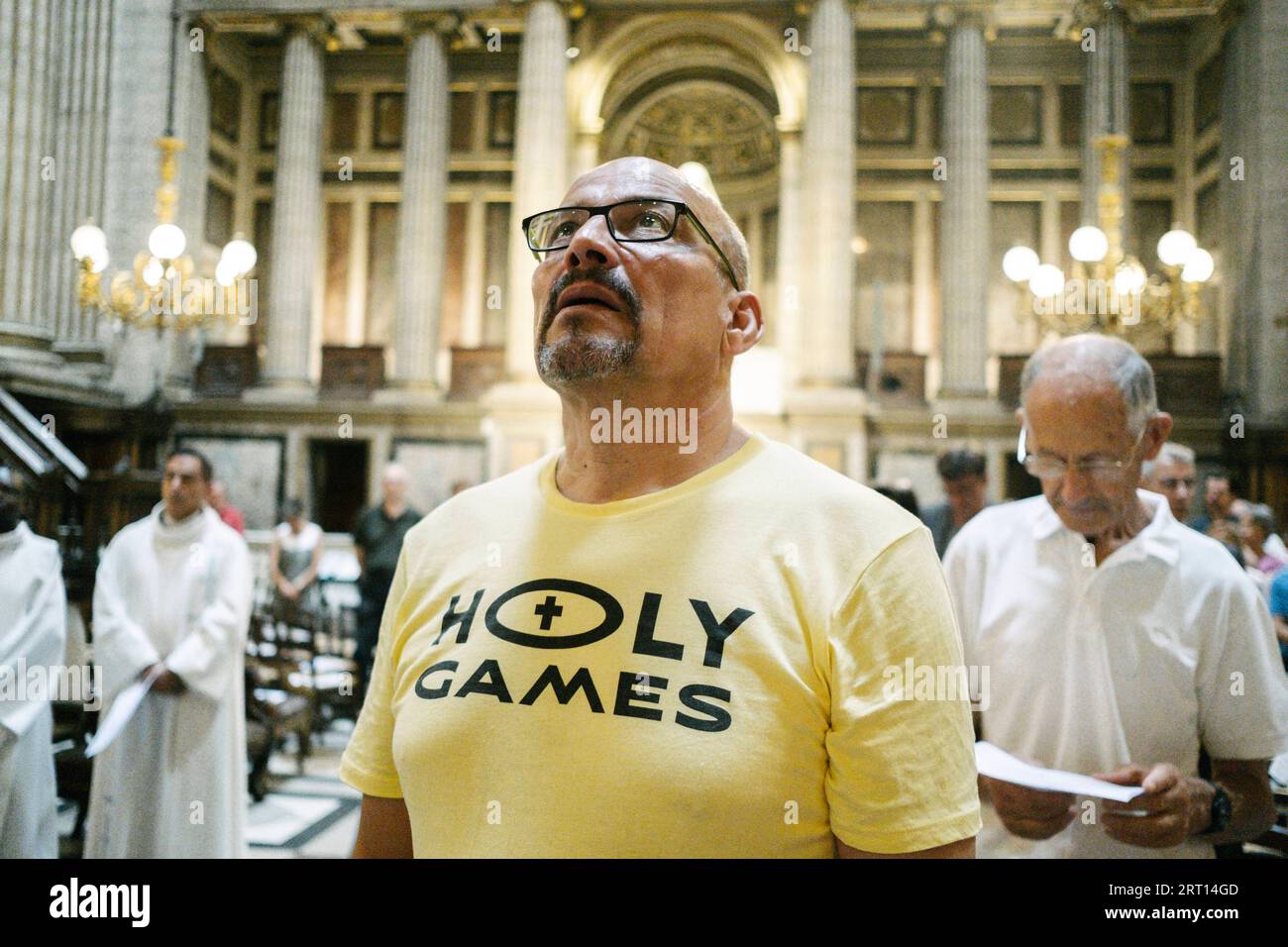 Parishioners wear a "Holy games" t shirt during the blessing of the ...