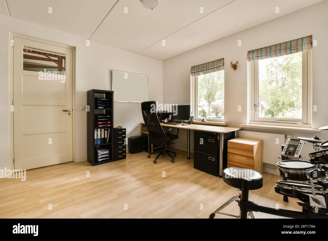 a home office area with wood floors and white walls, including a desk ...