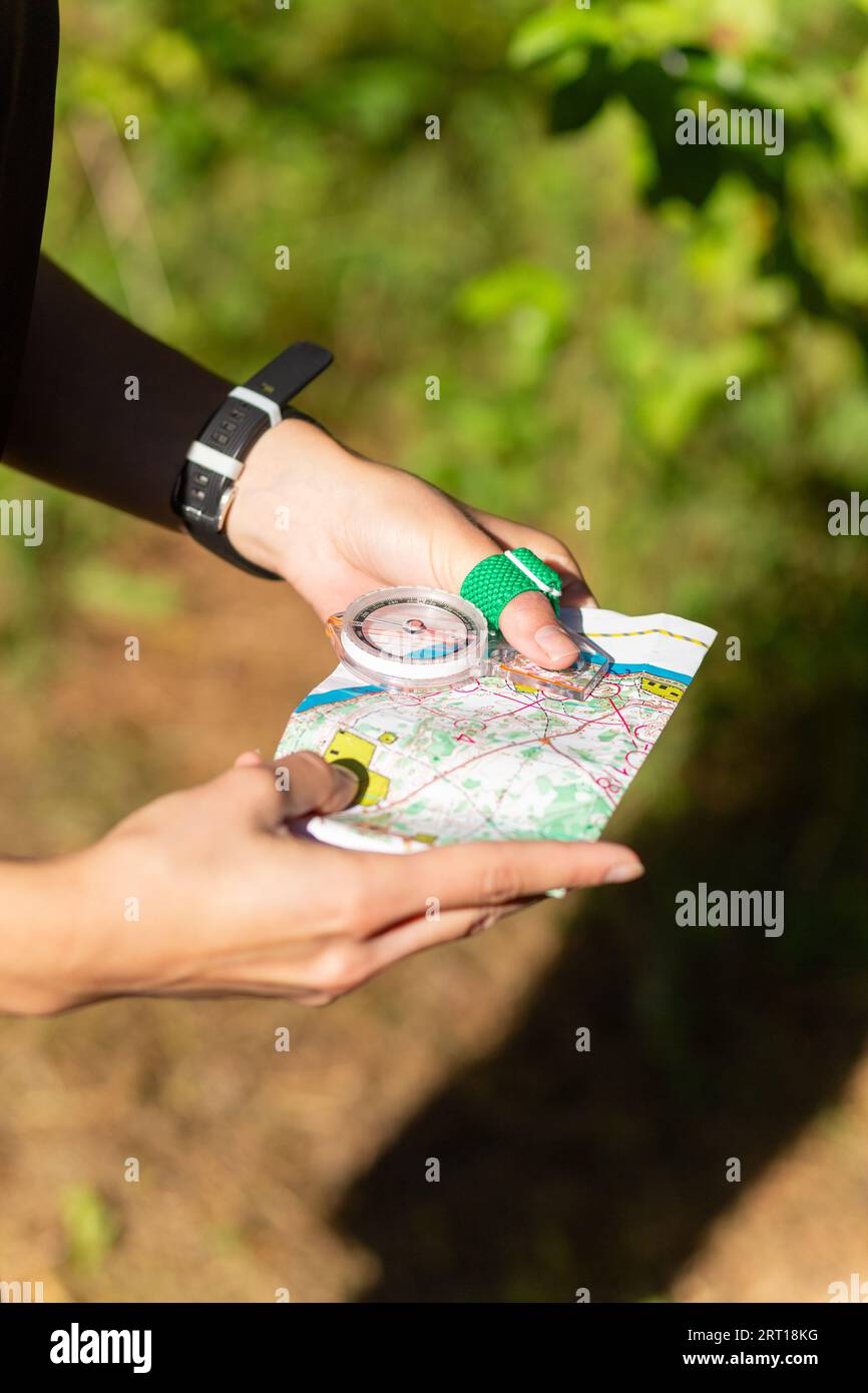 Woman holding a map and the compass during orienteering competitions ...