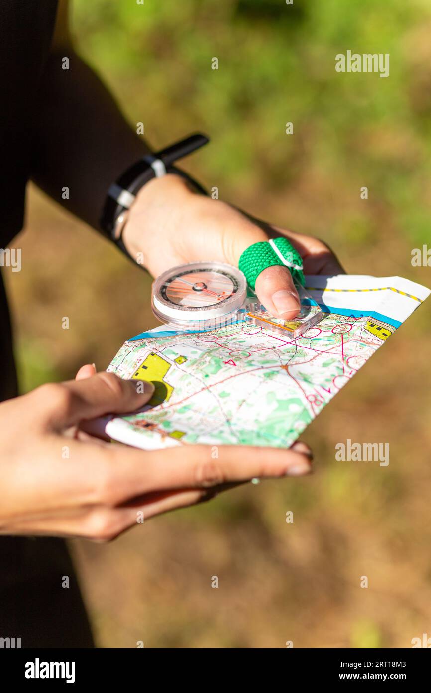 Woman holding a map and the compass during orienteering competitions ...