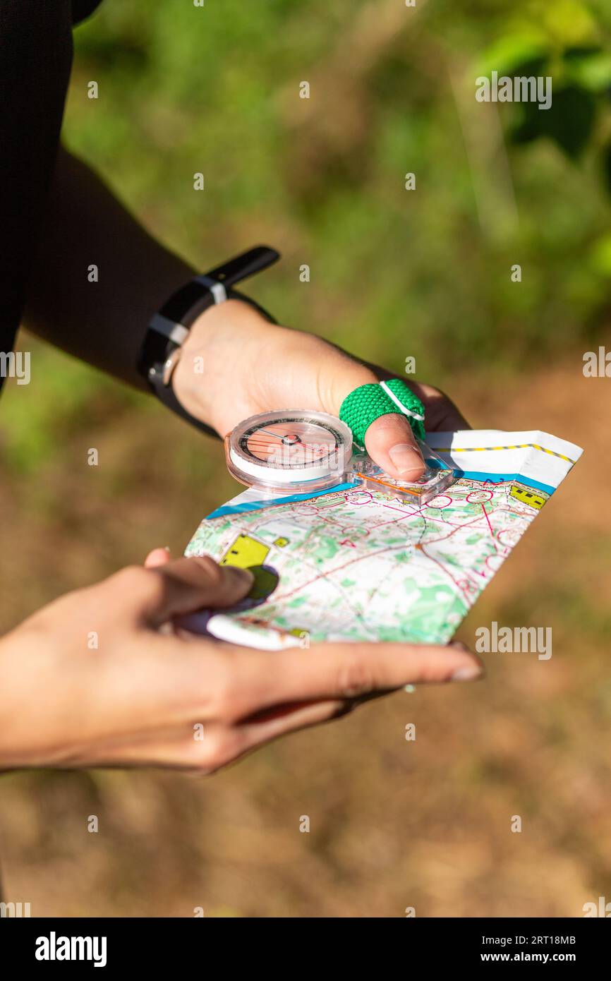 Woman holding a map and the compass during orienteering competitions ...