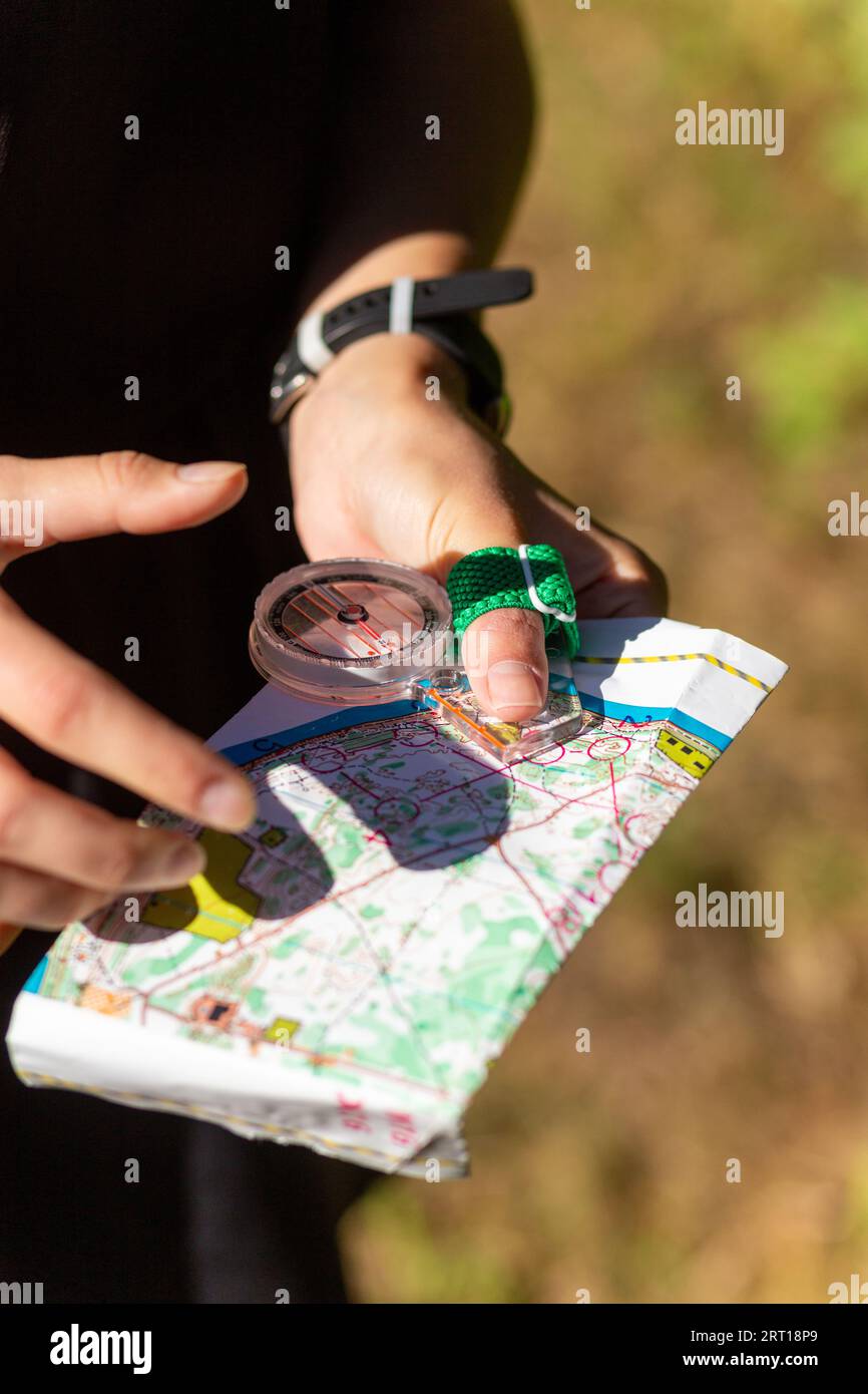 Woman holding a map and the compass during orienteering competitions ...